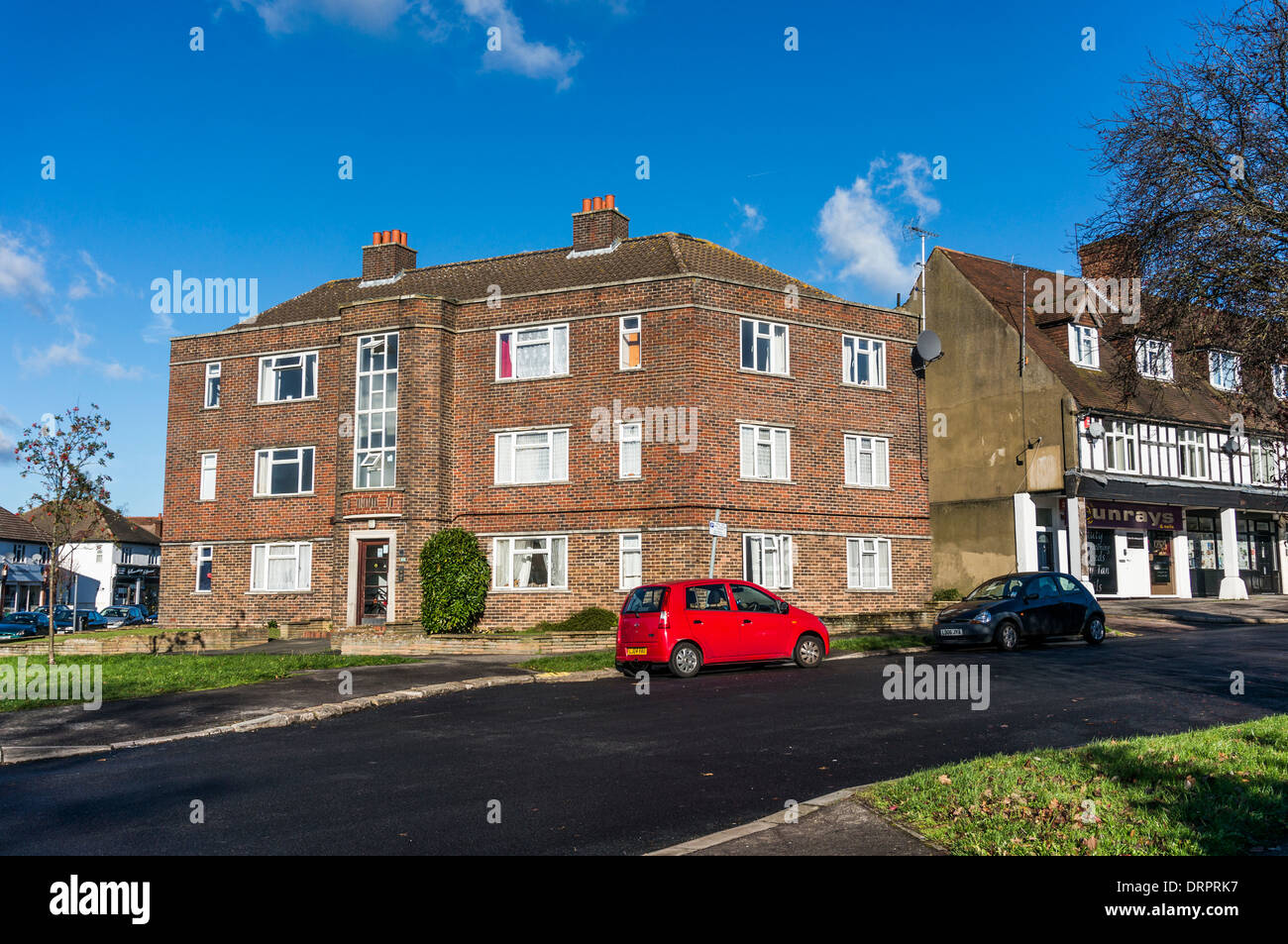 A block of flats and some shops against a blue sky, located on the Nork ...