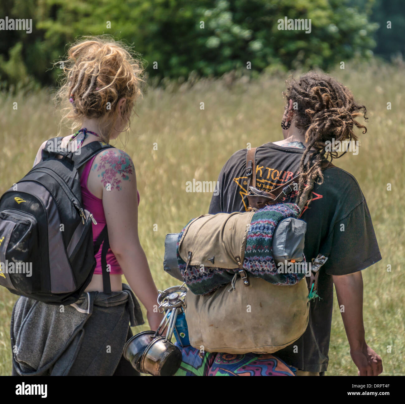 Young hippie backpacking couple, walking side by side on Box Hill ...