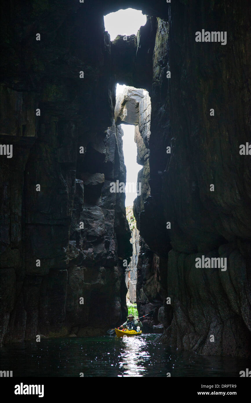 Sea kayaker in the chasm of Pollnashantunny, Inishmurray isalnd, County ...