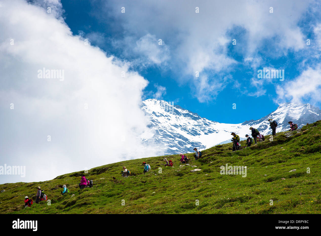 Japanese tourists on walking trail by the Eiger and Jungfrau mountains ...