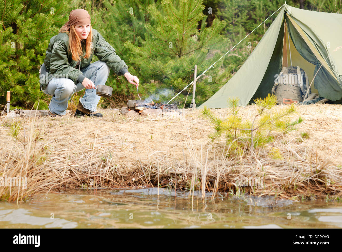 Camping woman tent cook food fire nature Stock Photo - Alamy