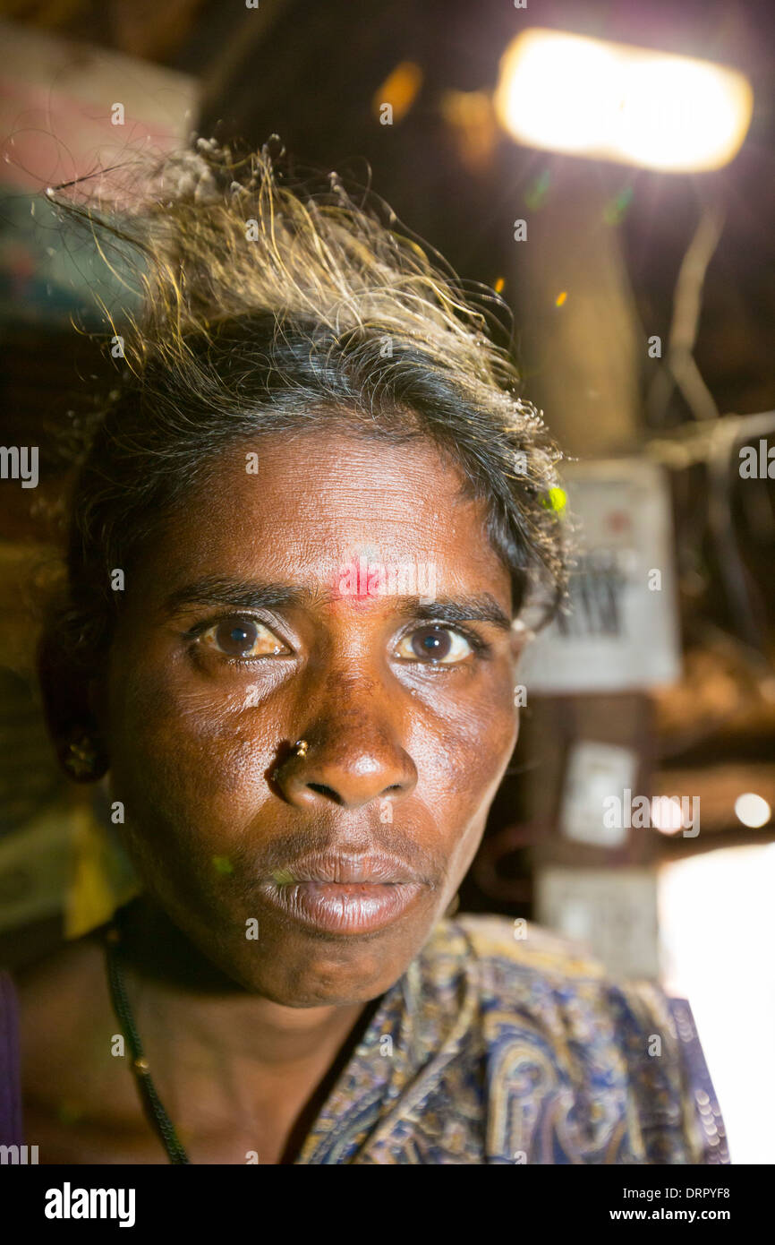An untouchable woman in her hut, illuminated by an electric light ...