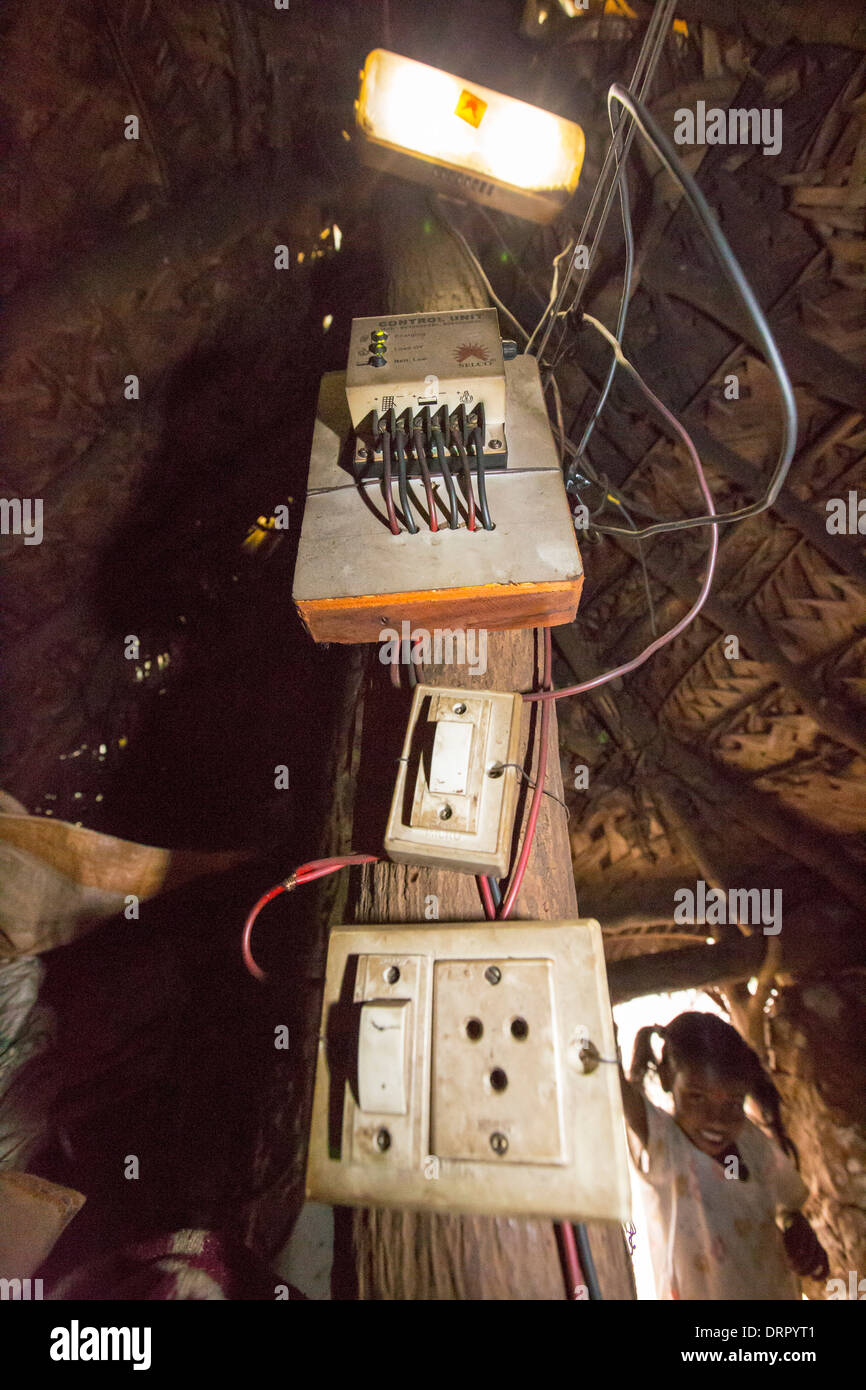 An untouchable familes hut, illuminated by an electric light, powered ...