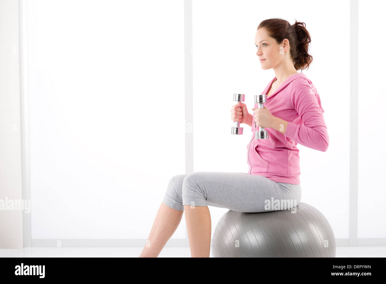Fitness woman exercise dumbbell ball gym Stock Photo - Alamy