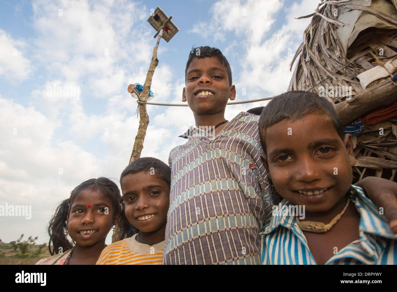 An untouchable family outside their hut, illuminated by an electric ...