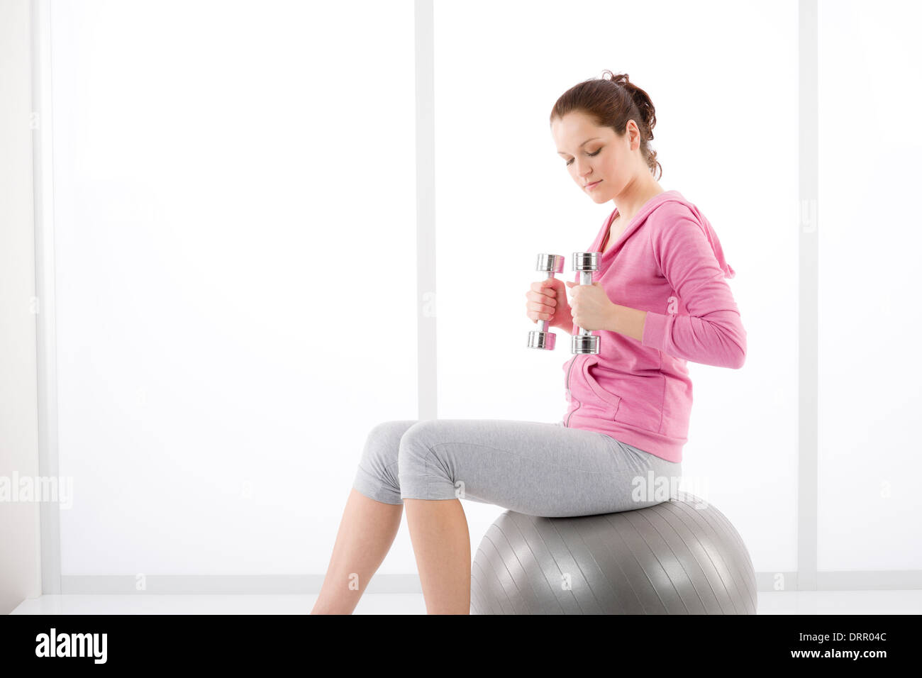 Fitness woman exercise dumbbell ball gym Stock Photo - Alamy