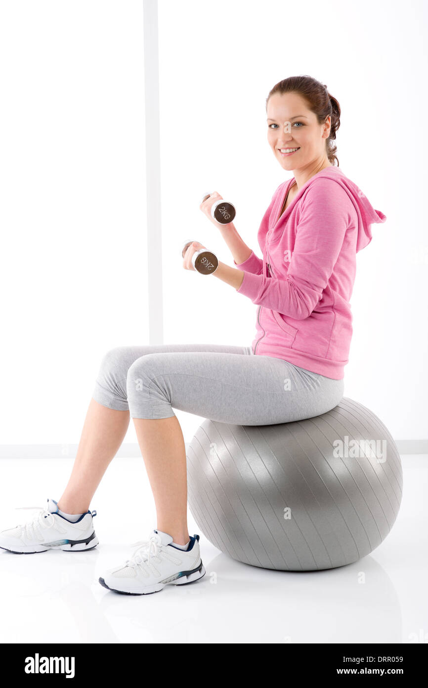 Fitness woman exercise dumbbell ball gym Stock Photo - Alamy