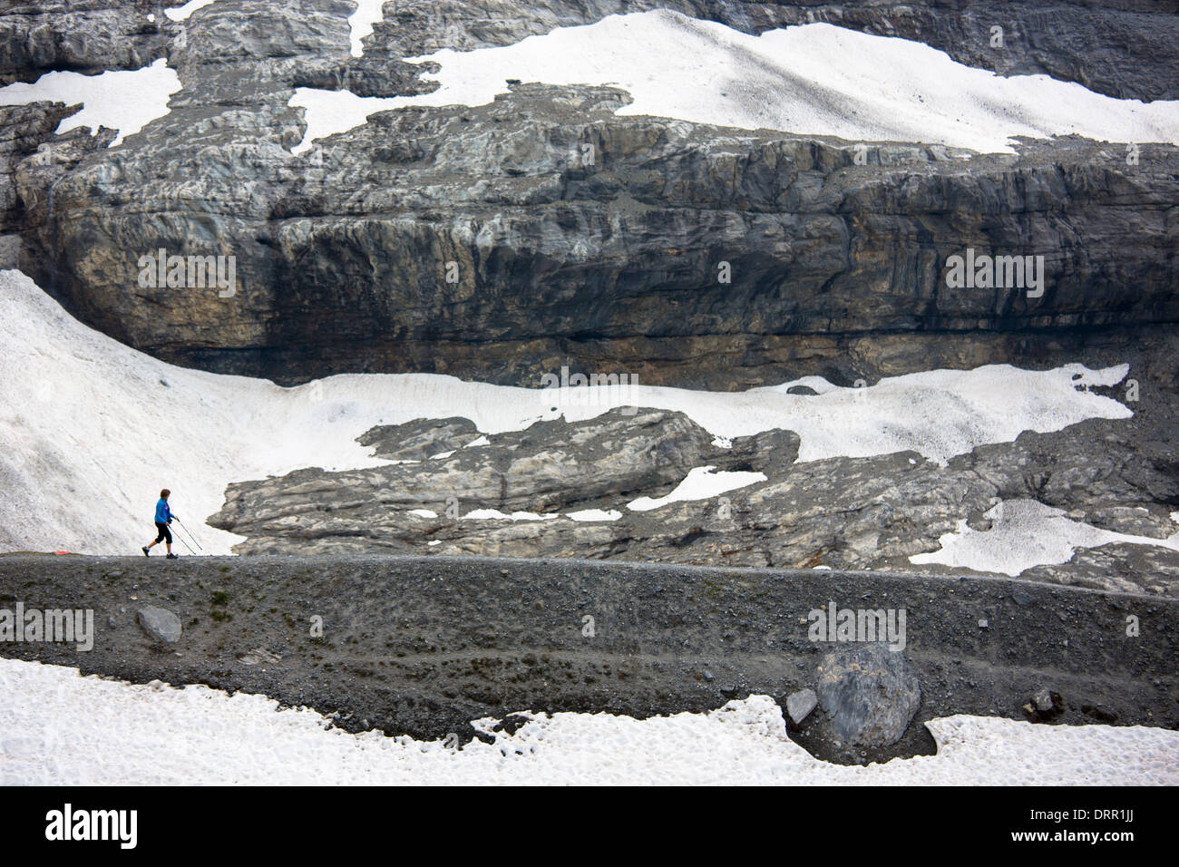 Hiker with walking poles on the Eiger Trail by the Eiger Glacier ...