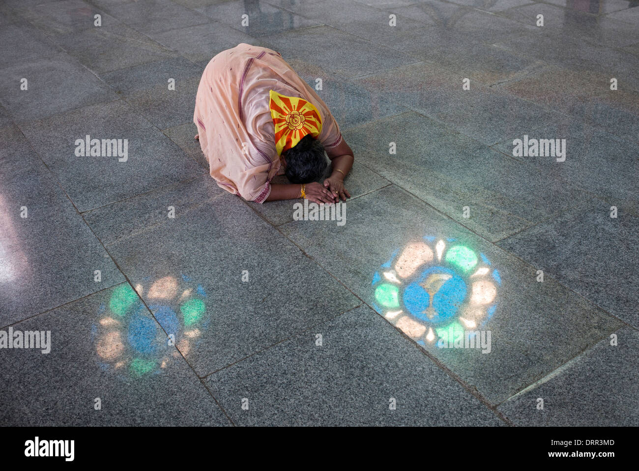 Indian woman prostrating Inside the prayer hall at Sathya Sai Baba ...