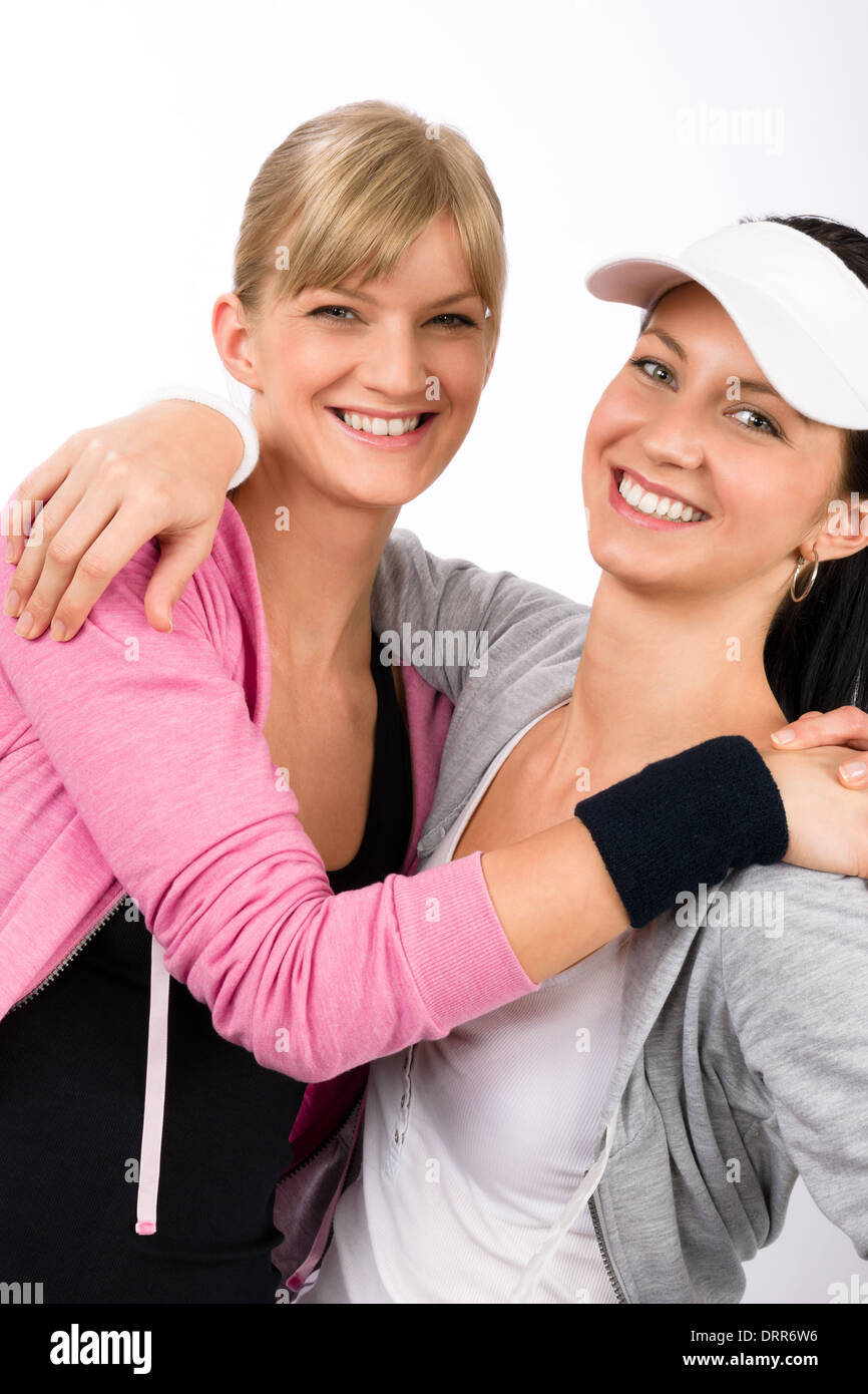 Two sport woman friends hugging smiling Stock Photo - Alamy