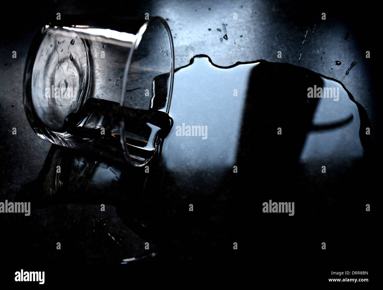 Reflections of water spilled from a glass Stock Photo - Alamy