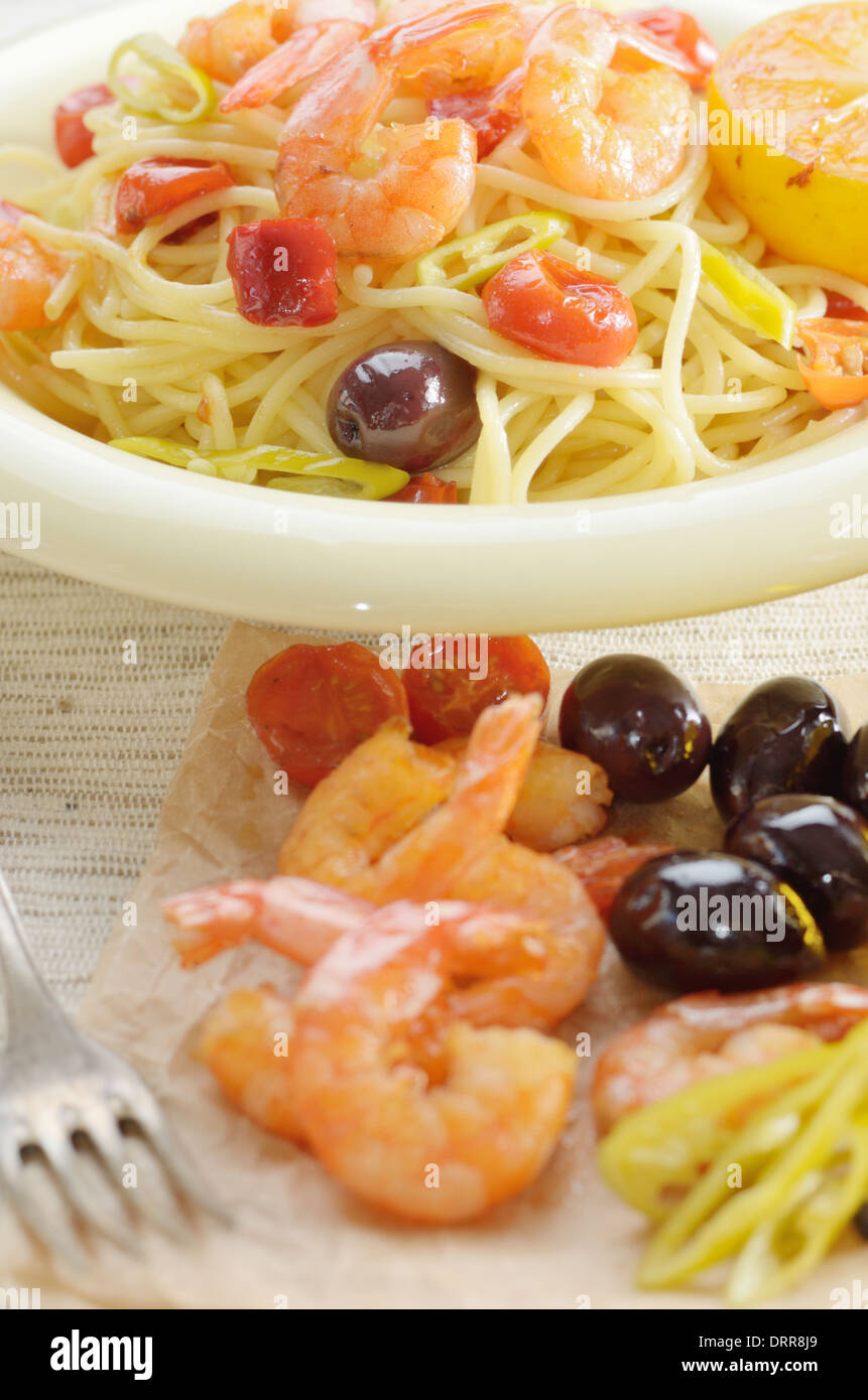 Seafood spaghetti pasta dish with shrimps cherry tomatoes and olives ...
