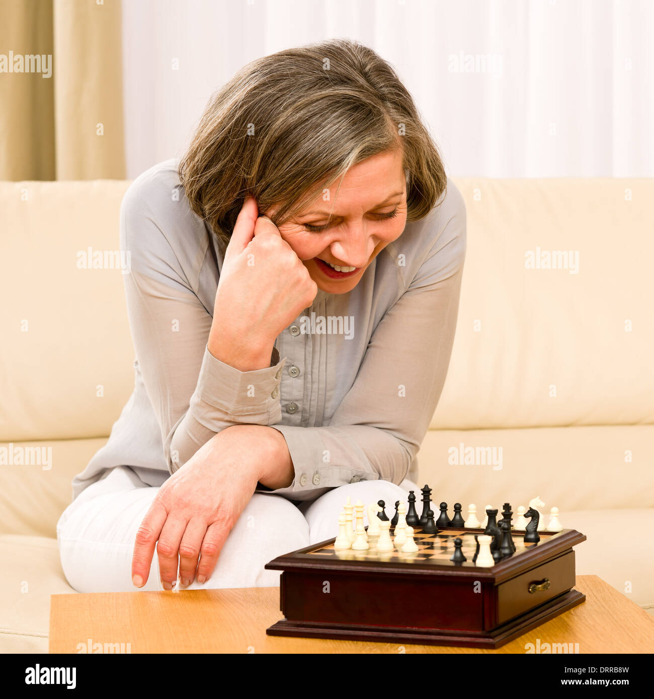 Senior woman play chess happy sit on sofa Stock Photo - Alamy