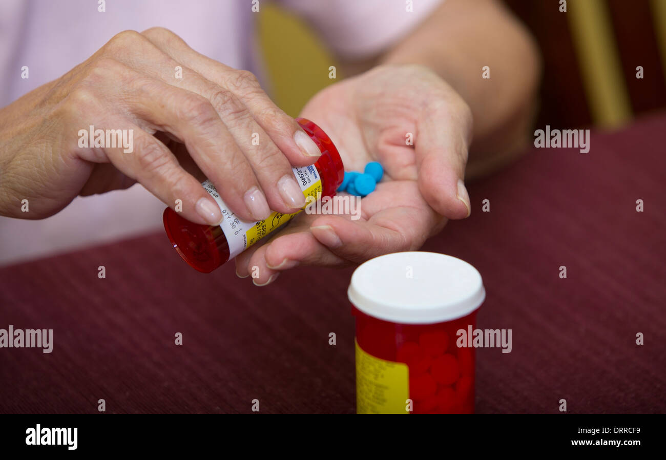 Female 74 year old senior citizen organizes her prescription drug ...