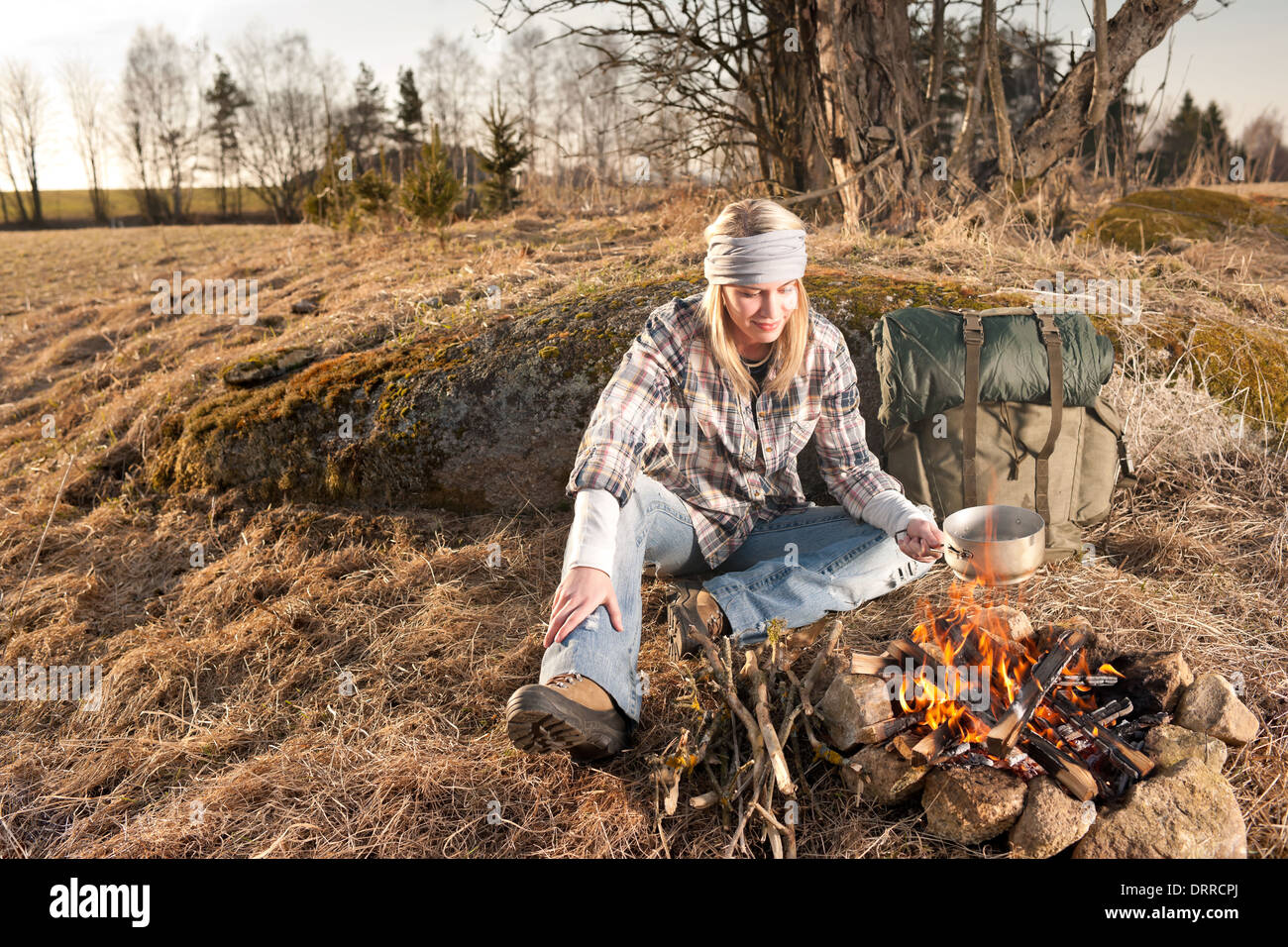 Hiking woman with backpack cook by campfire Stock Photo - Alamy