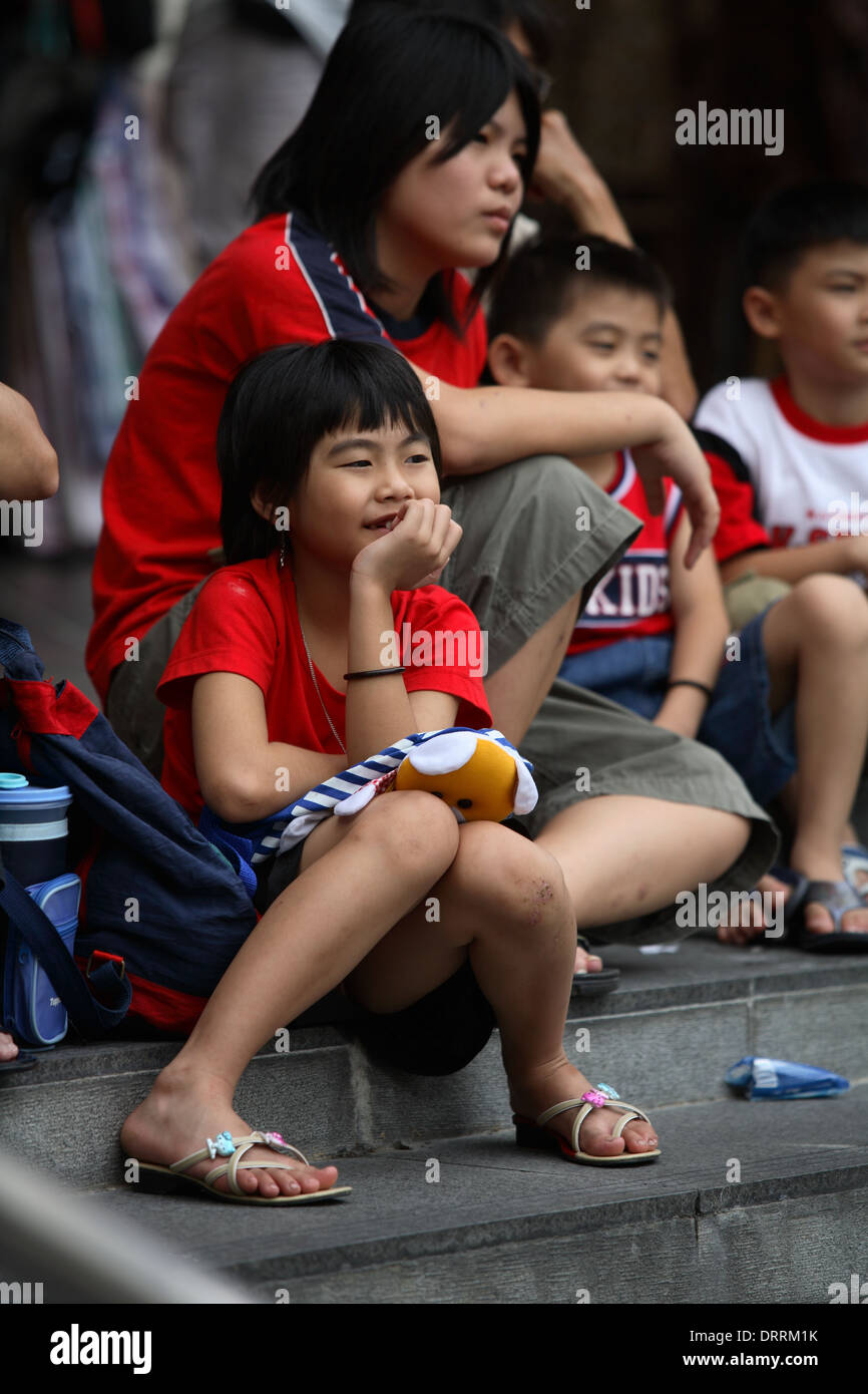 People - smiling girl sitting around a plaza in Chinatown, Singapore ...