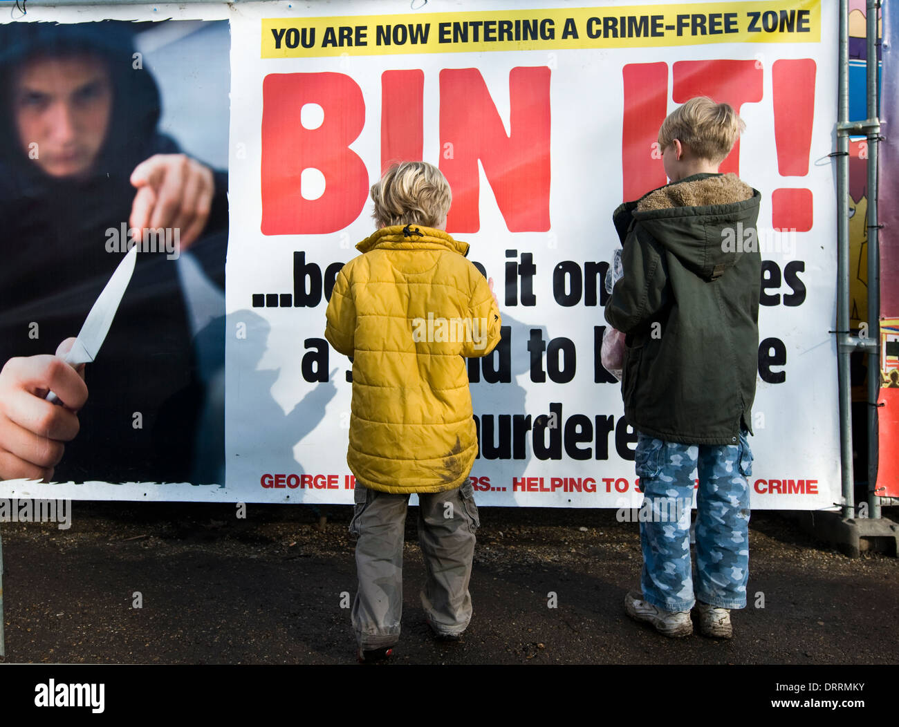 Two boys look at a knife crime billboard warning about the dangers of ...
