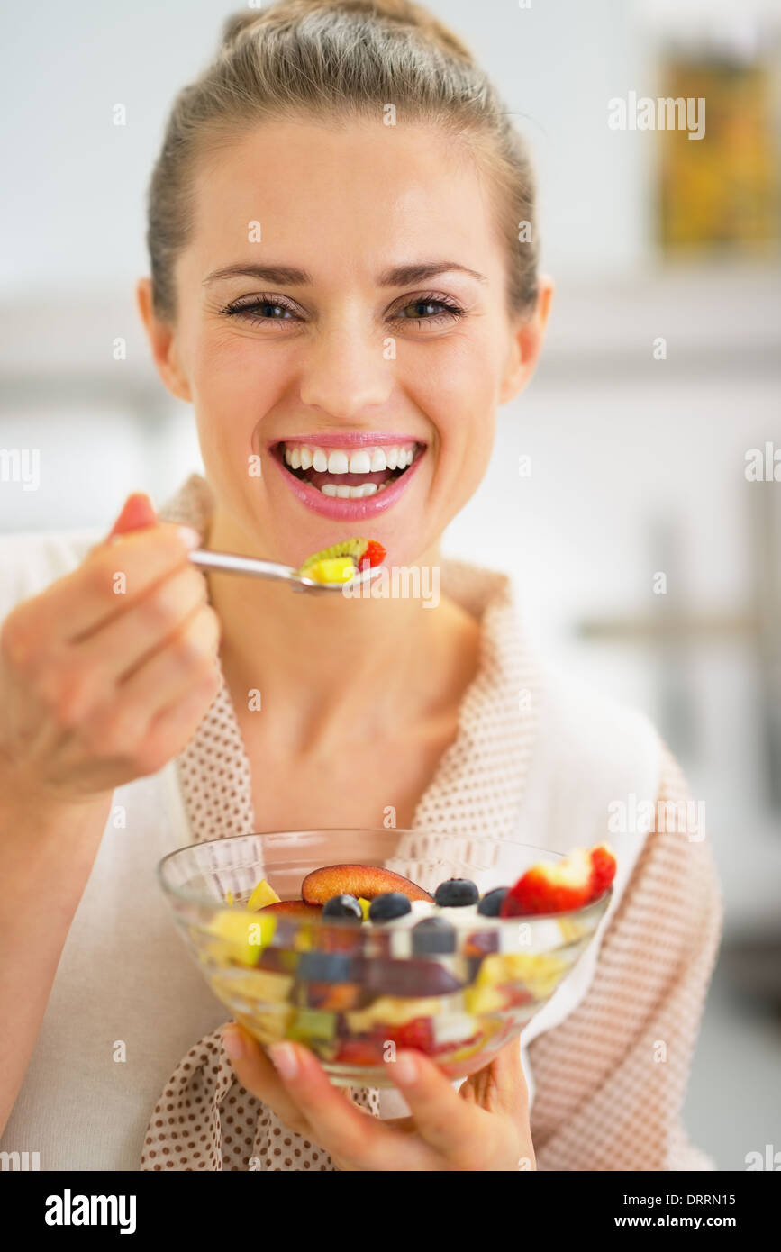 Smiling young woman eating fresh fruit salad Stock Photo - Alamy