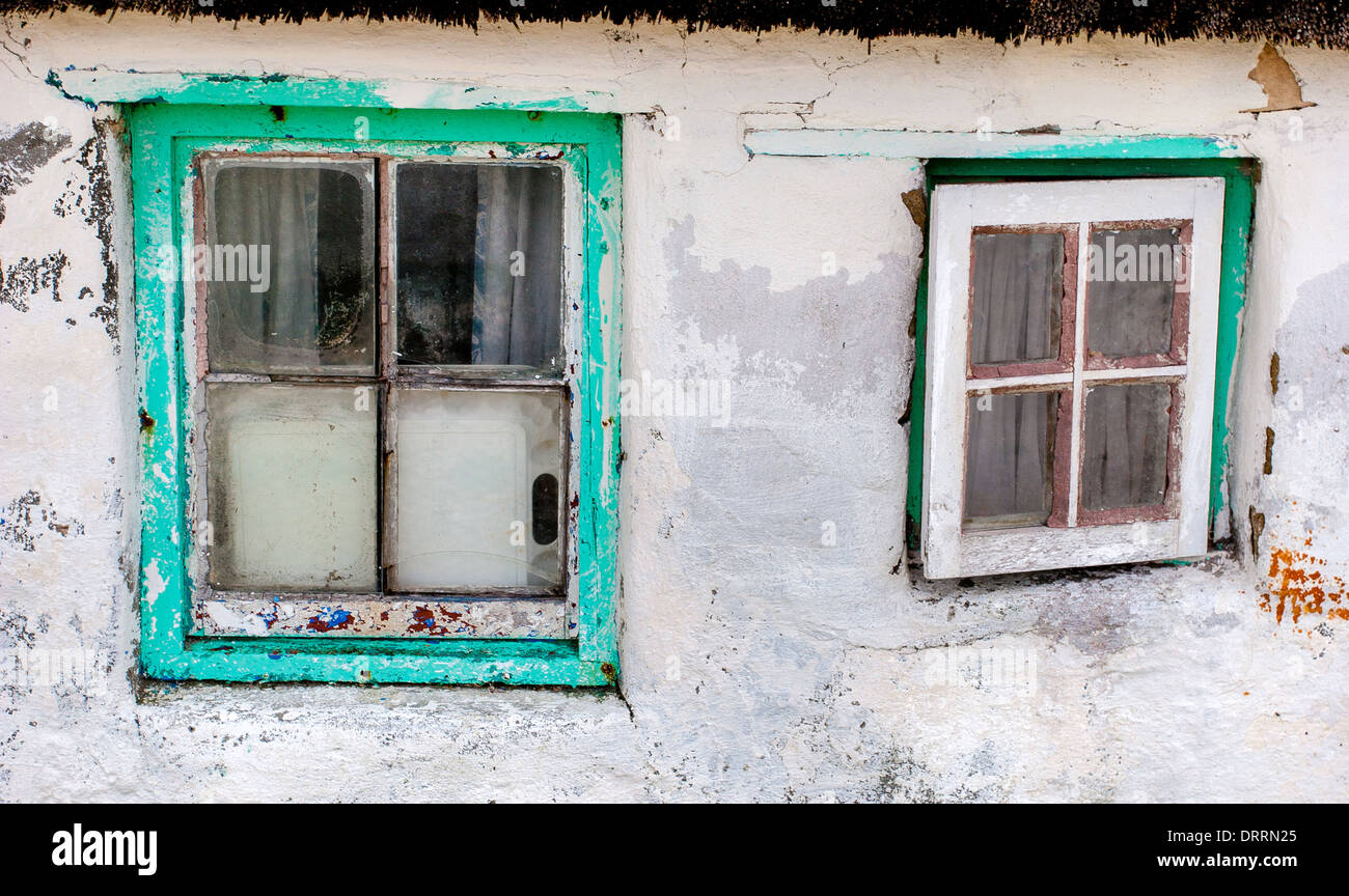 Painted wooden windows in the whitewashed wall of a house in Arniston ...