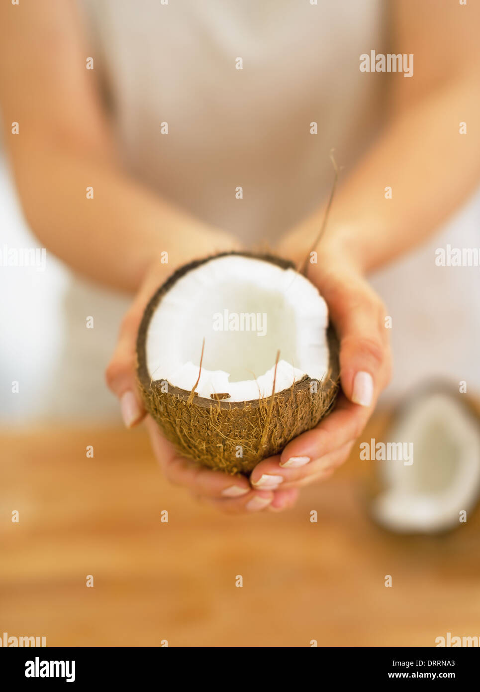 Closeup on young woman showing coconut half Stock Photo - Alamy