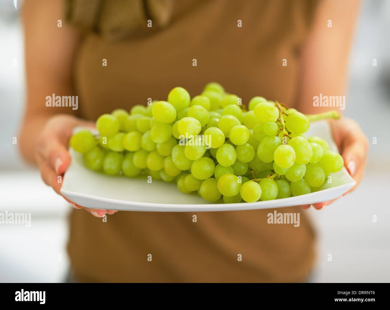 Closeup on young woman showing branch of grapes Stock Photo - Alamy