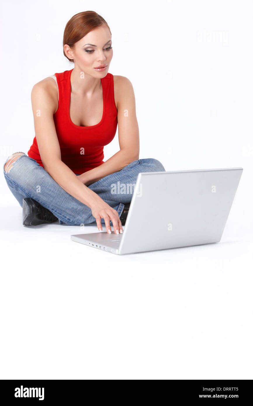 Cute female sitting and using a laptop Stock Photo - Alamy