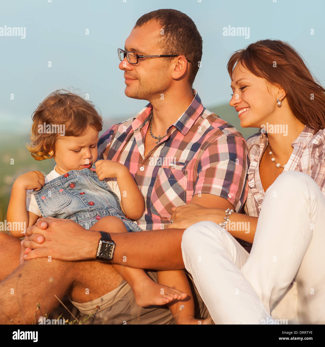 Happy mother, father and daughter in sunset Stock Photo - Alamy