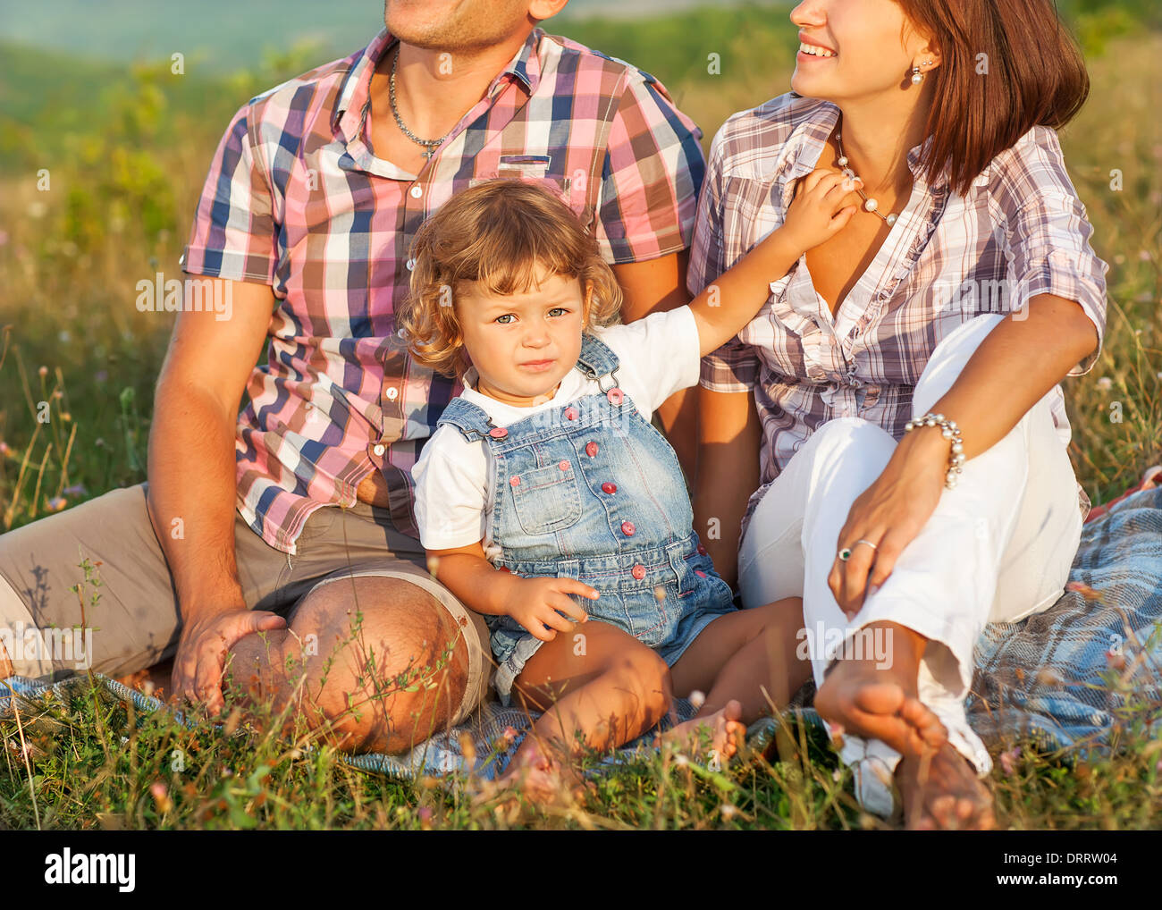 Happy mother, father and daughter in sunset Stock Photo - Alamy
