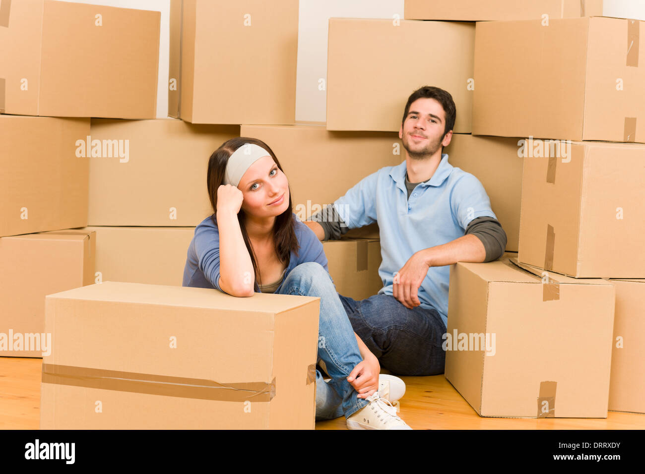 Moving new home young couple sitting floor Stock Photo - Alamy