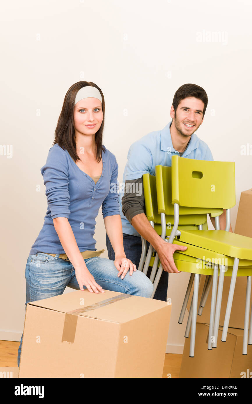 Moving new home young couple carry chairs Stock Photo - Alamy