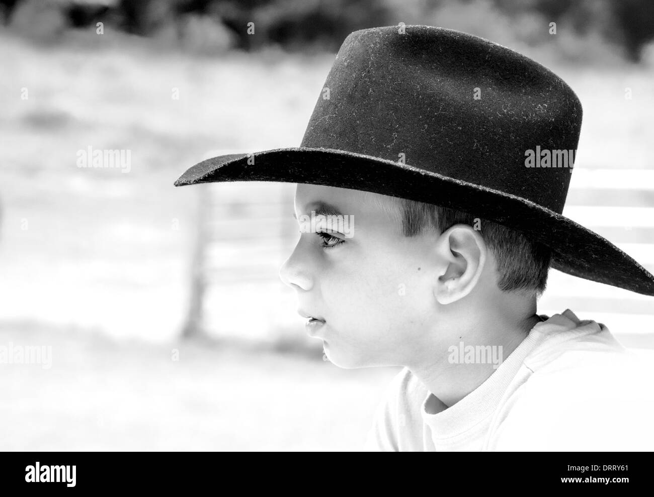 Black and White Portrait of young teen boy in black cowboy hat on ranch ...