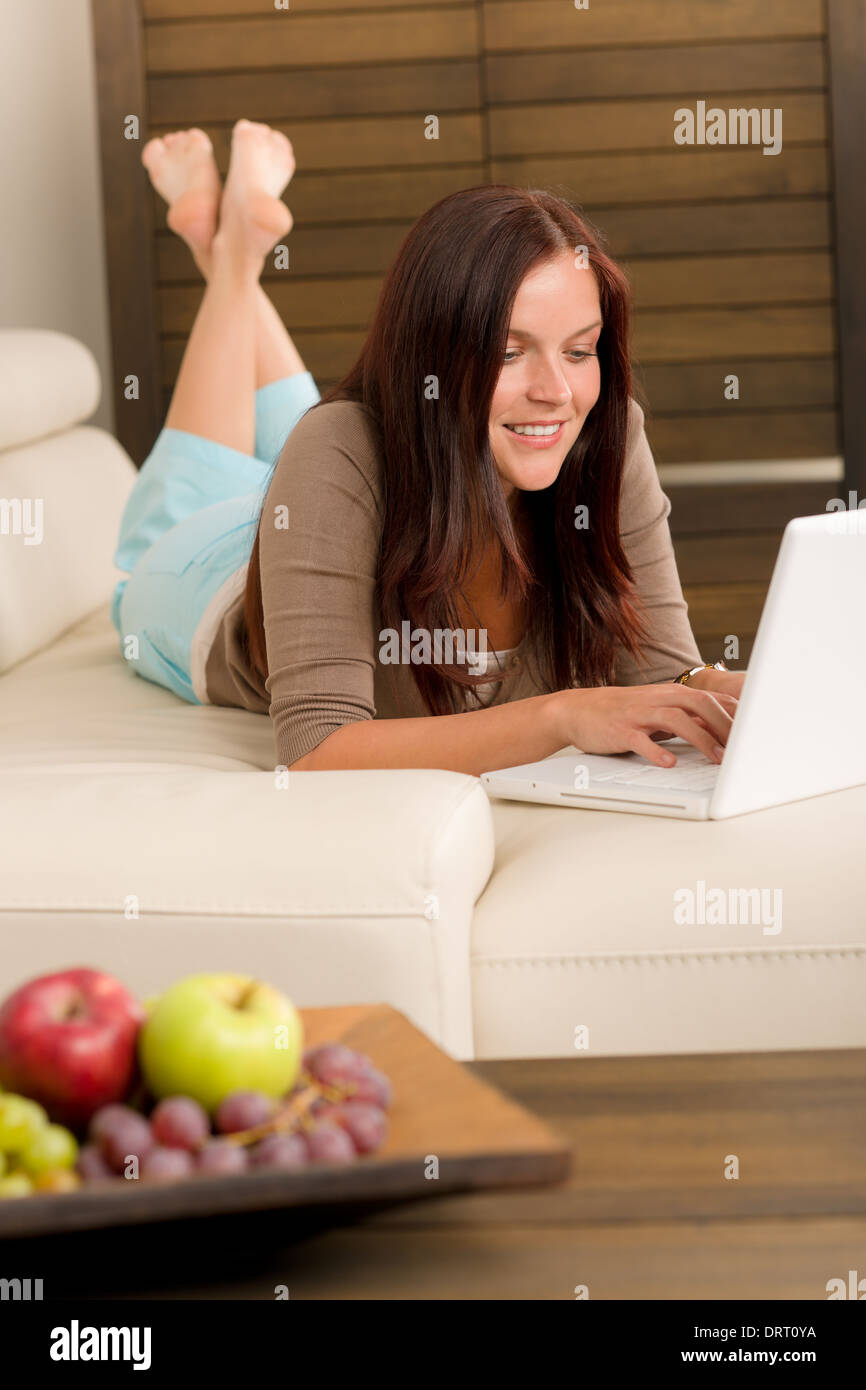 Modern living room woman lying sofa laptop Stock Photo - Alamy
