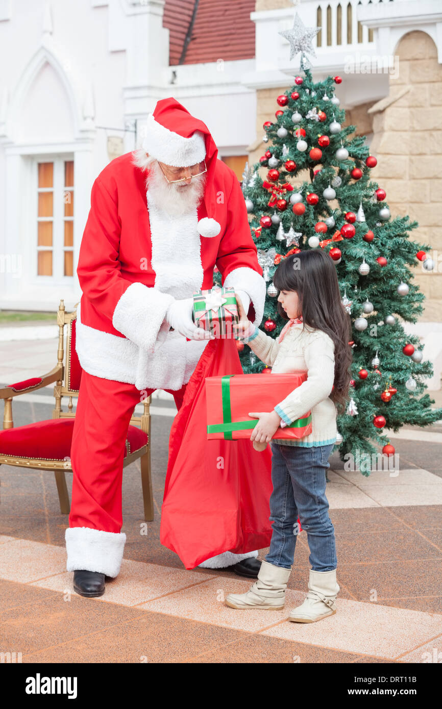 Girl Taking Presents From Santa Claus Stock Photo - Alamy
