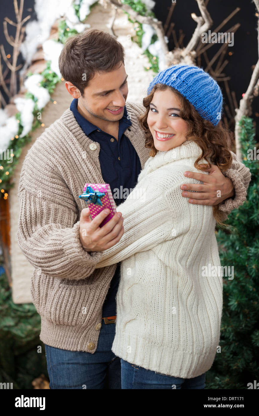 Couple Embracing In Christmas Store Stock Photo - Alamy