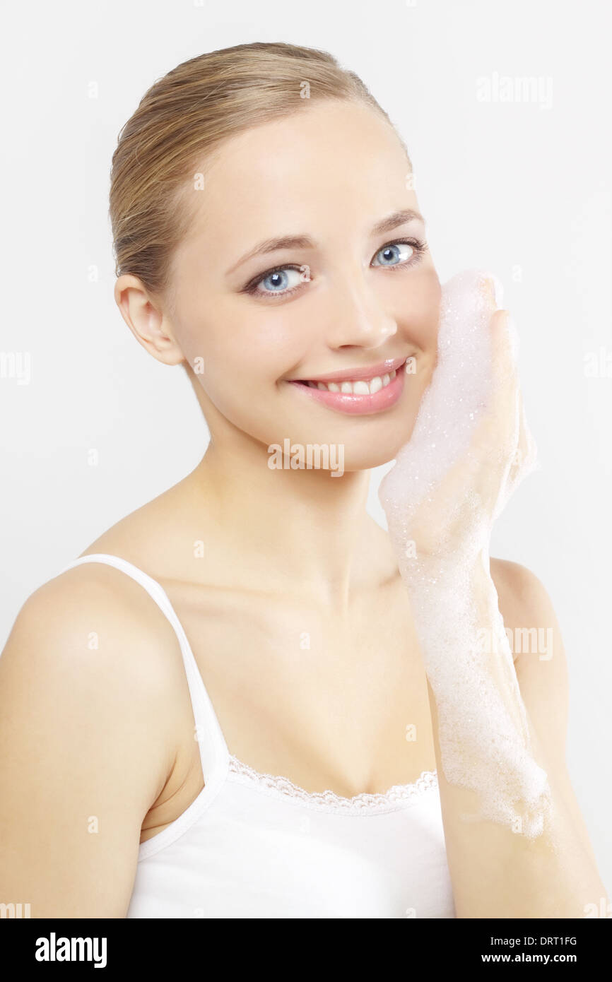 Beautiful girl washing her face on gray Stock Photo - Alamy