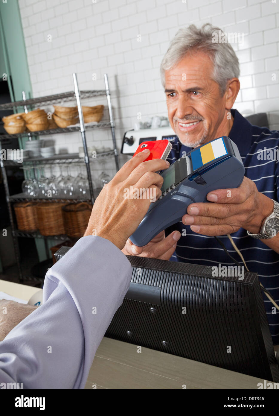 Customer Paying Through Mobile Phone In Store Stock Photo - Alamy