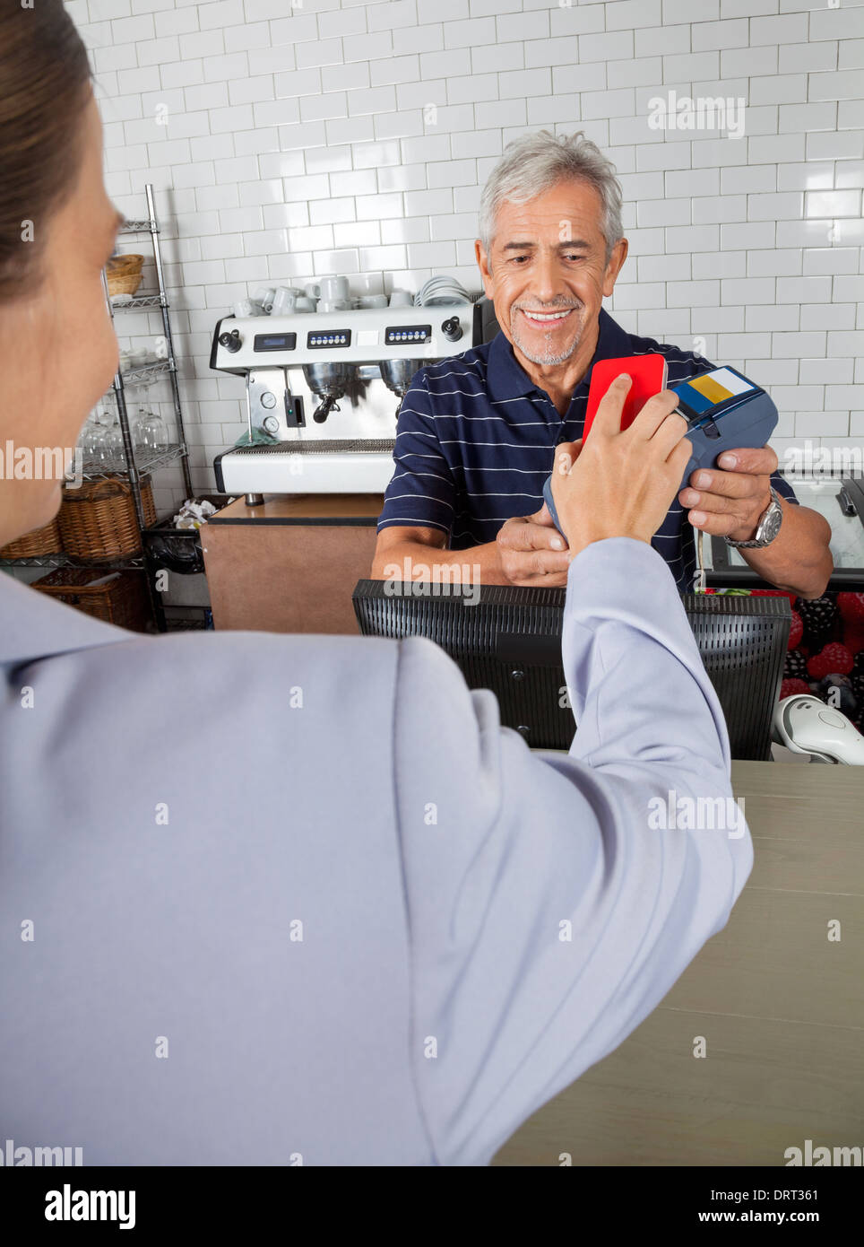 Customer Making Payment Through Mobile Phone In Store Stock Photo - Alamy
