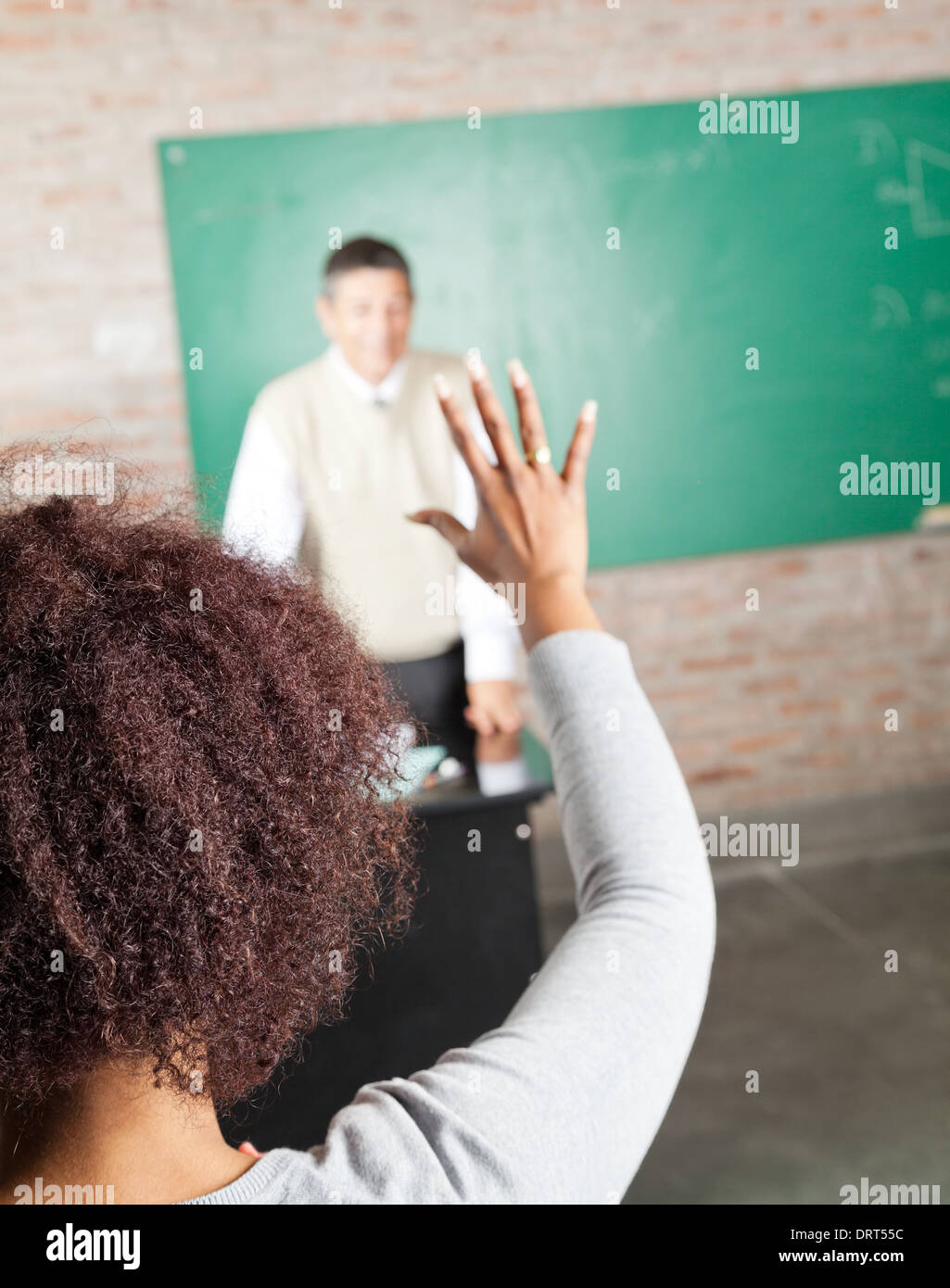College Student Raising Hand To Answer In Classroom Stock Photo - Alamy