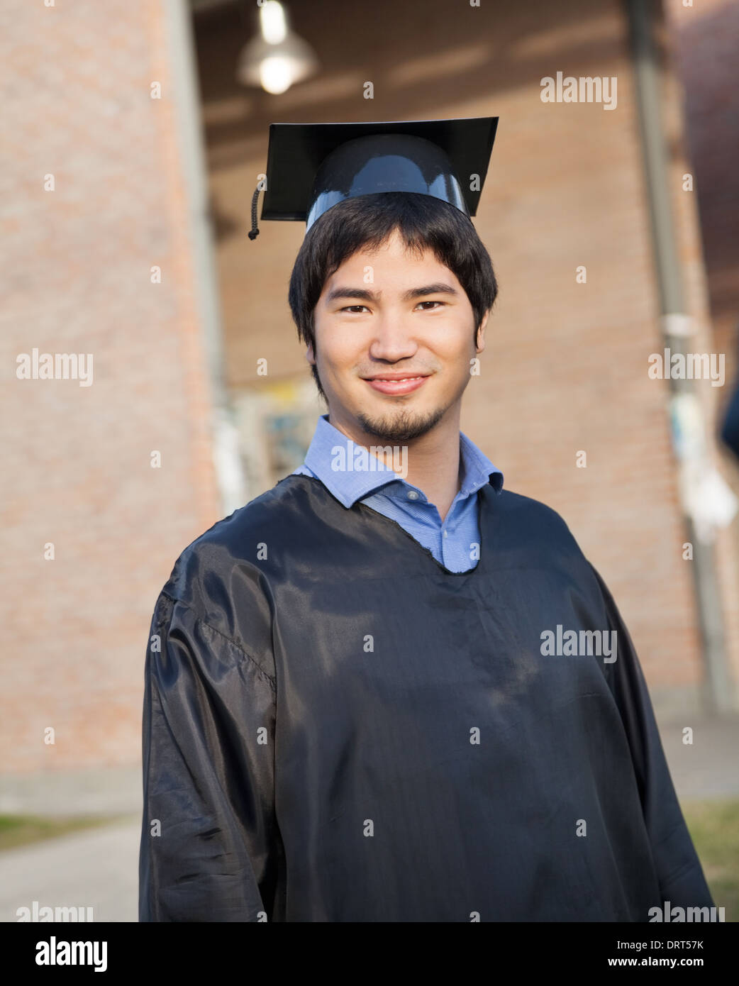 Male Student In Graduation Gown And Mortar Board On Campus Stock Photo ...