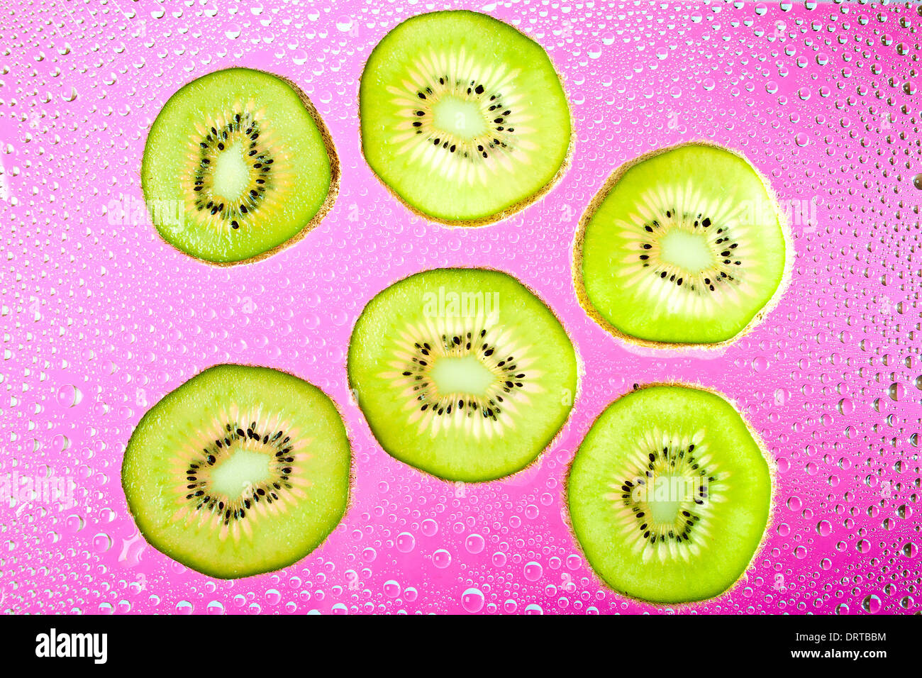 Kiwi segments on purpule background Stock Photo - Alamy