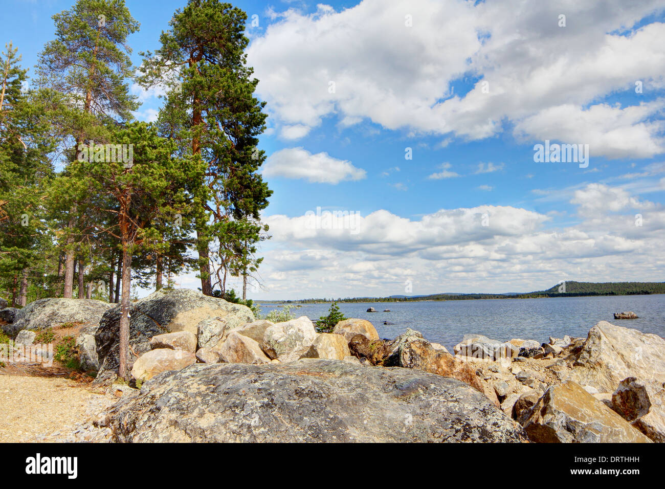 Beautiful landscape with lake shore, stones and pines Stock Photo - Alamy