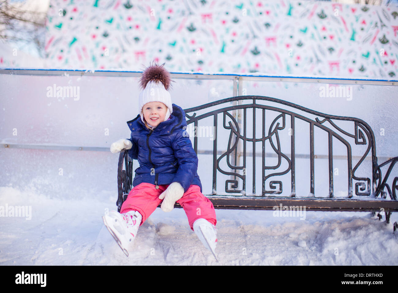 Little girl sitting on a bench in the skating rink Stock Photo - Alamy