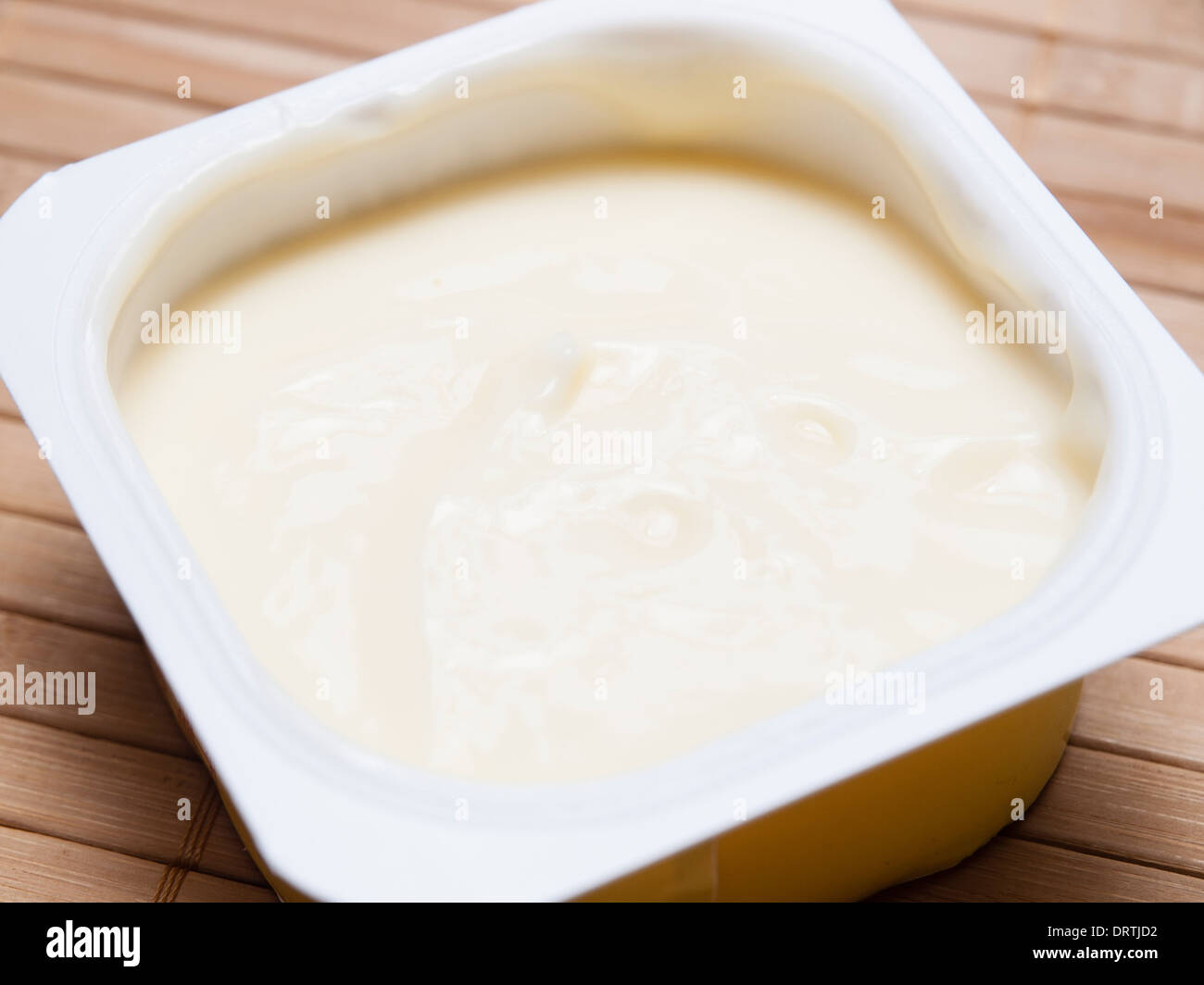 Vanilla custard in a plastic container on bamboo background Stock Photo ...