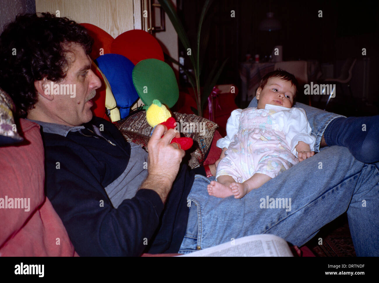 Father Shaking Teddy Rattle At Baby Trying to Get Her Attention Surrey ...