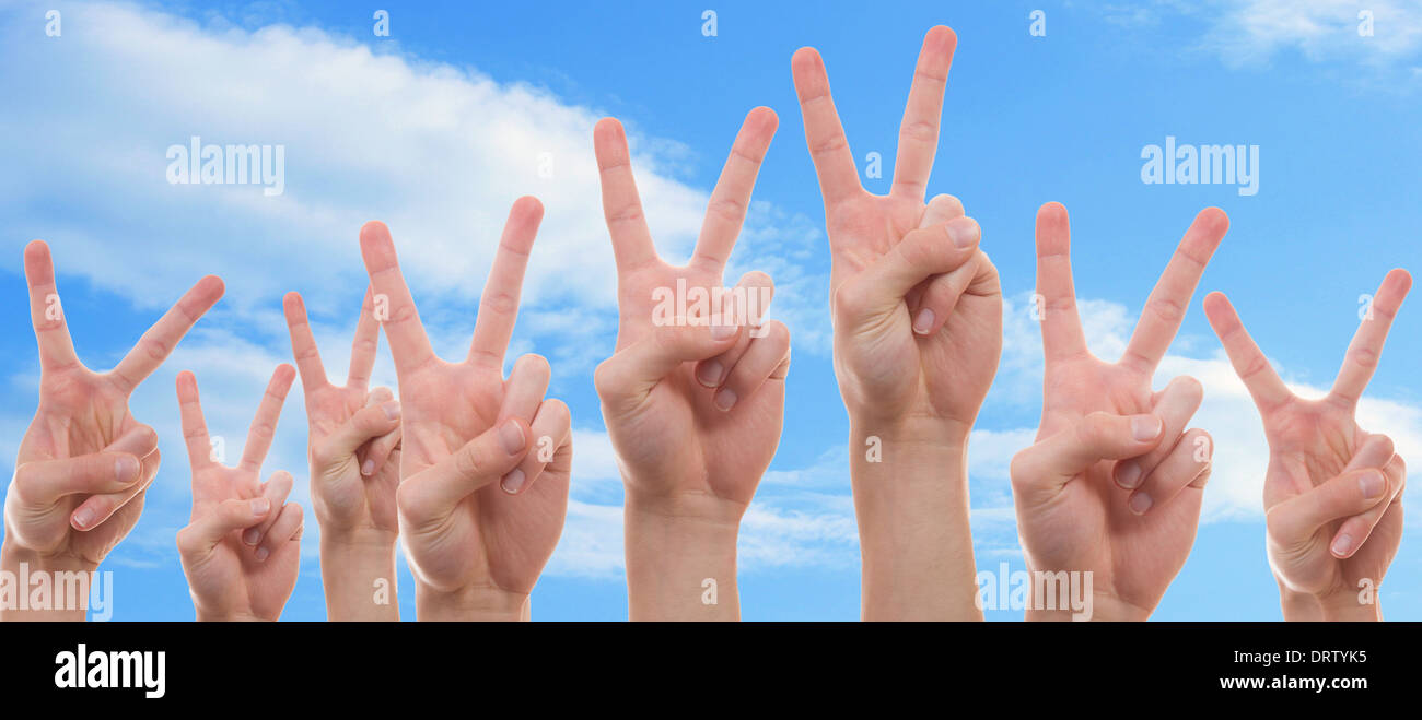 Teenagers raising their hands with two finger symbolizing peace Stock ...