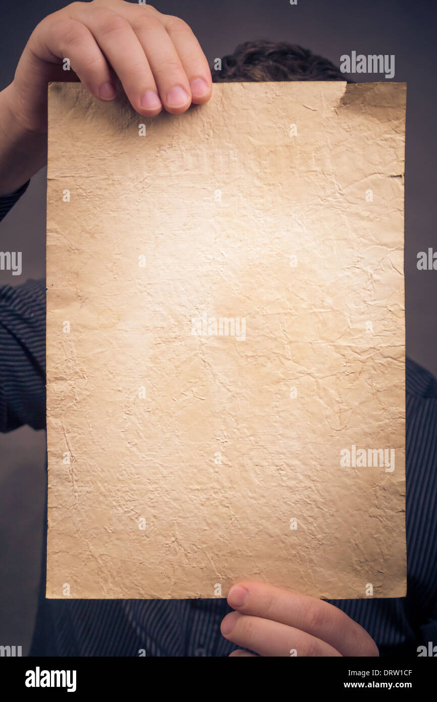 Old sheet of paper in his hands vertically Stock Photo - Alamy