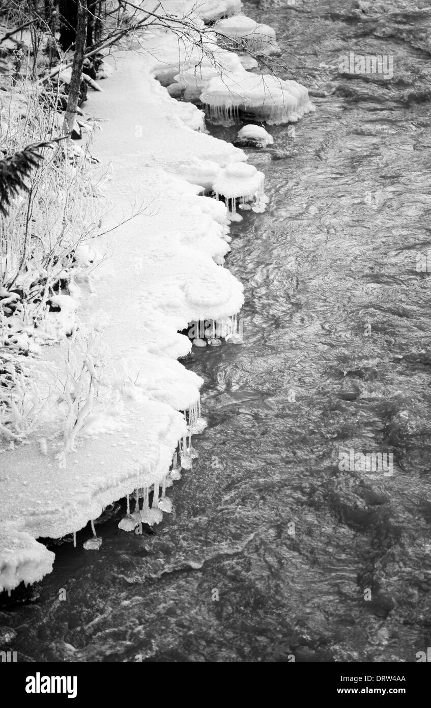 freezing river - ice is forming over the running water, phase boundary ...