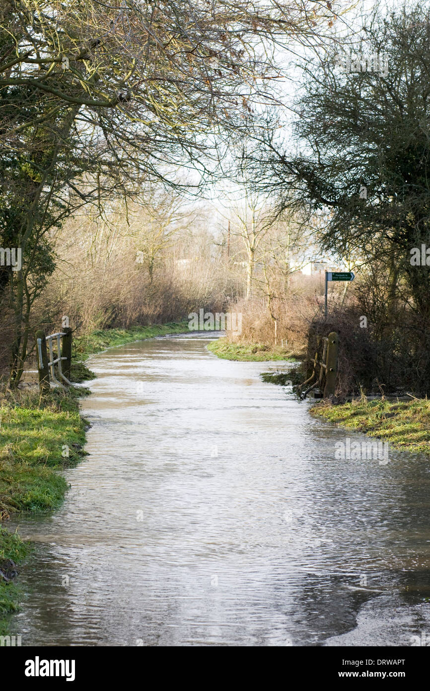 River bank overflowing flooding local village road in Oxfordshire Stock ...