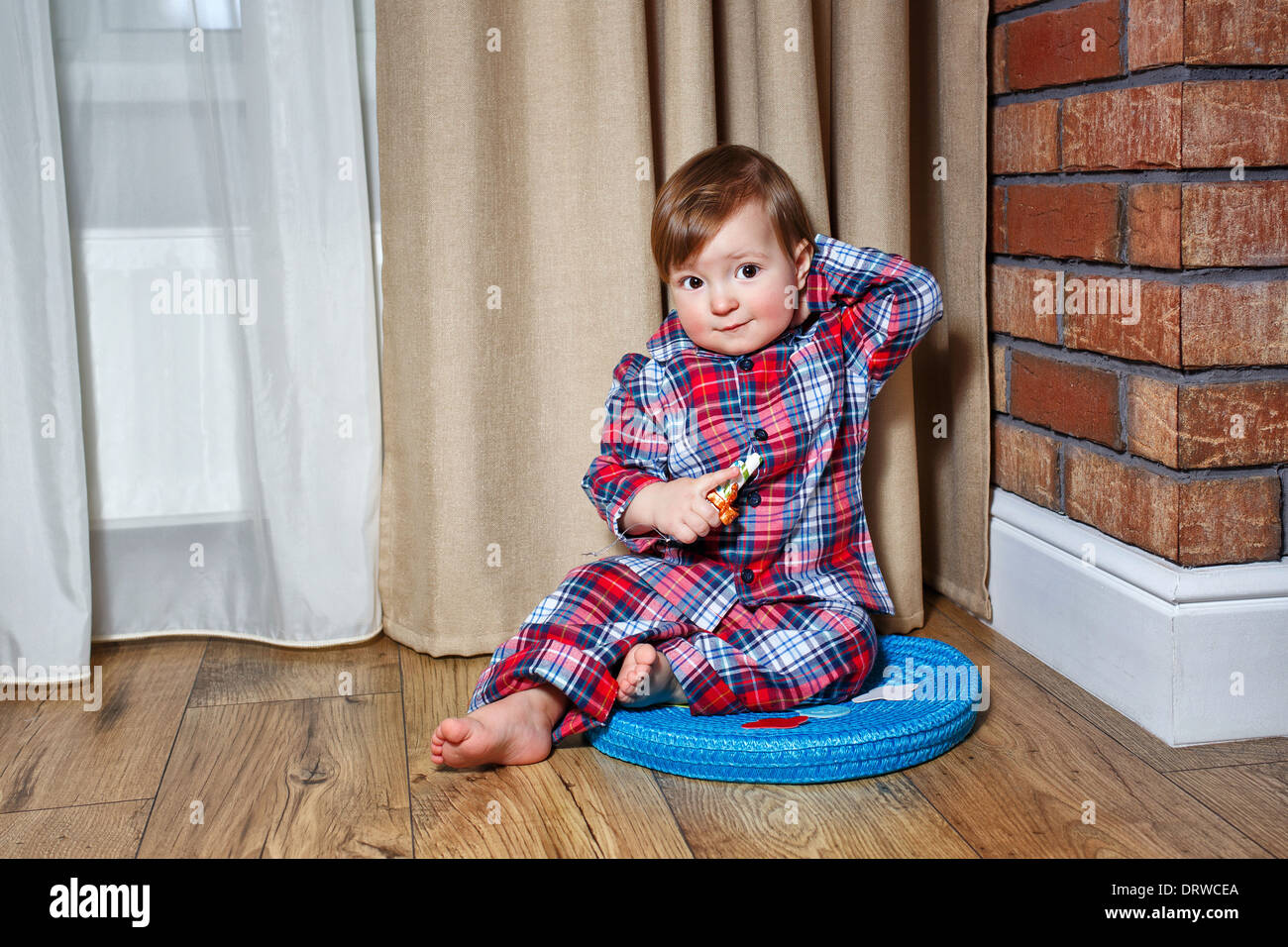 Cute little boy sitting on the floor in the living room Stock Photo - Alamy