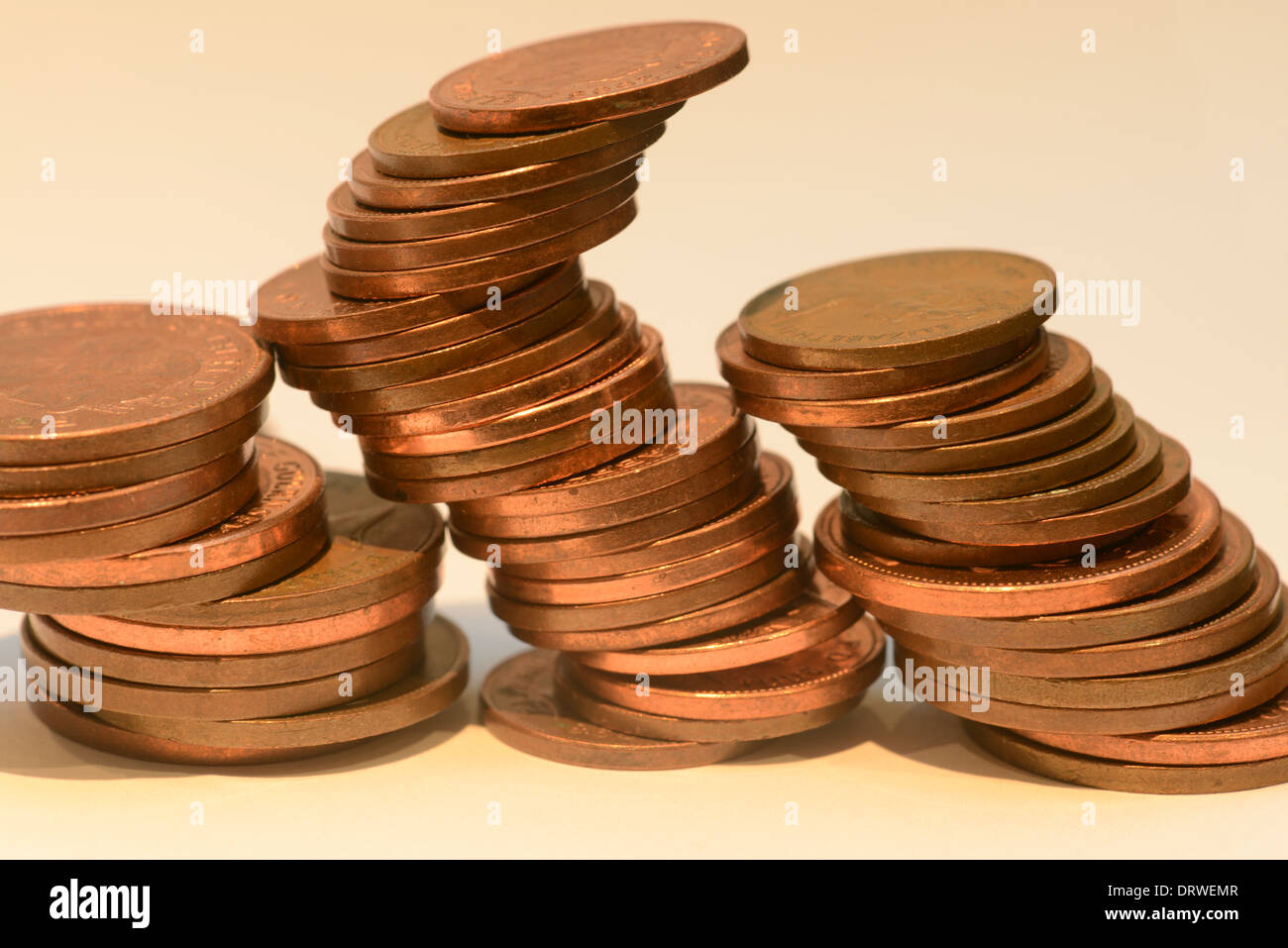 Toppling stacks of copper coins Stock Photo - Alamy